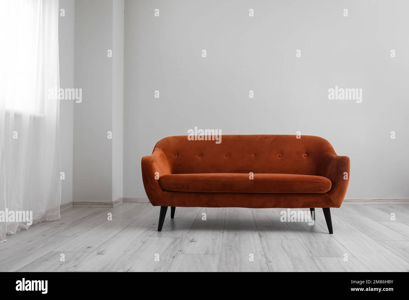Interior of light living room with brown sofa near window Stock Photo ...