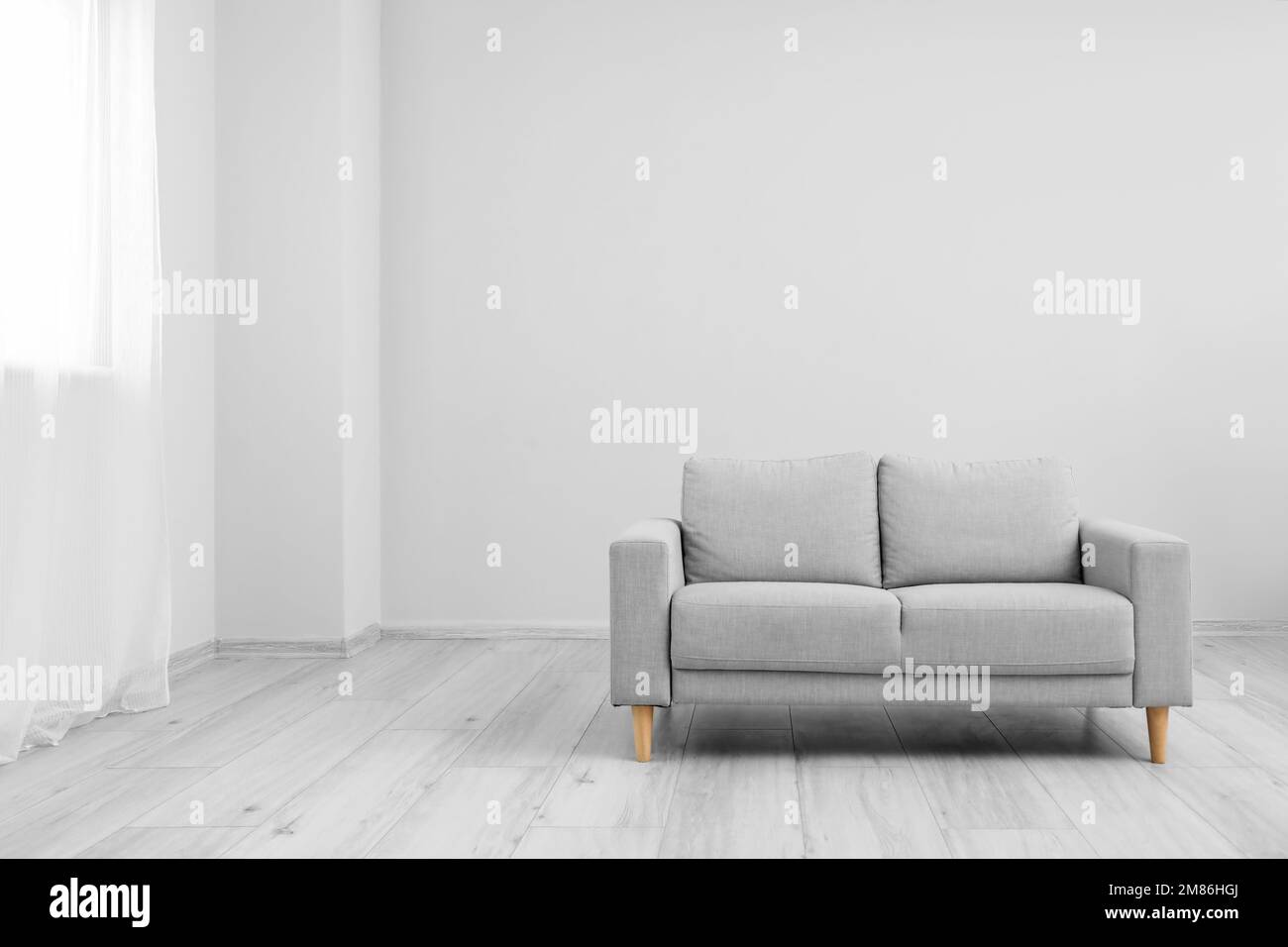 Interior of living room with grey sofa near window Stock Photo - Alamy