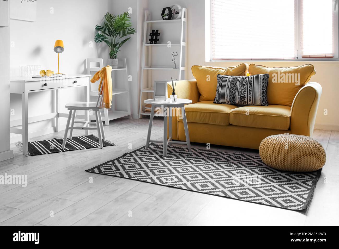 Interior of living room with yellow sofa near window Stock Photo - Alamy