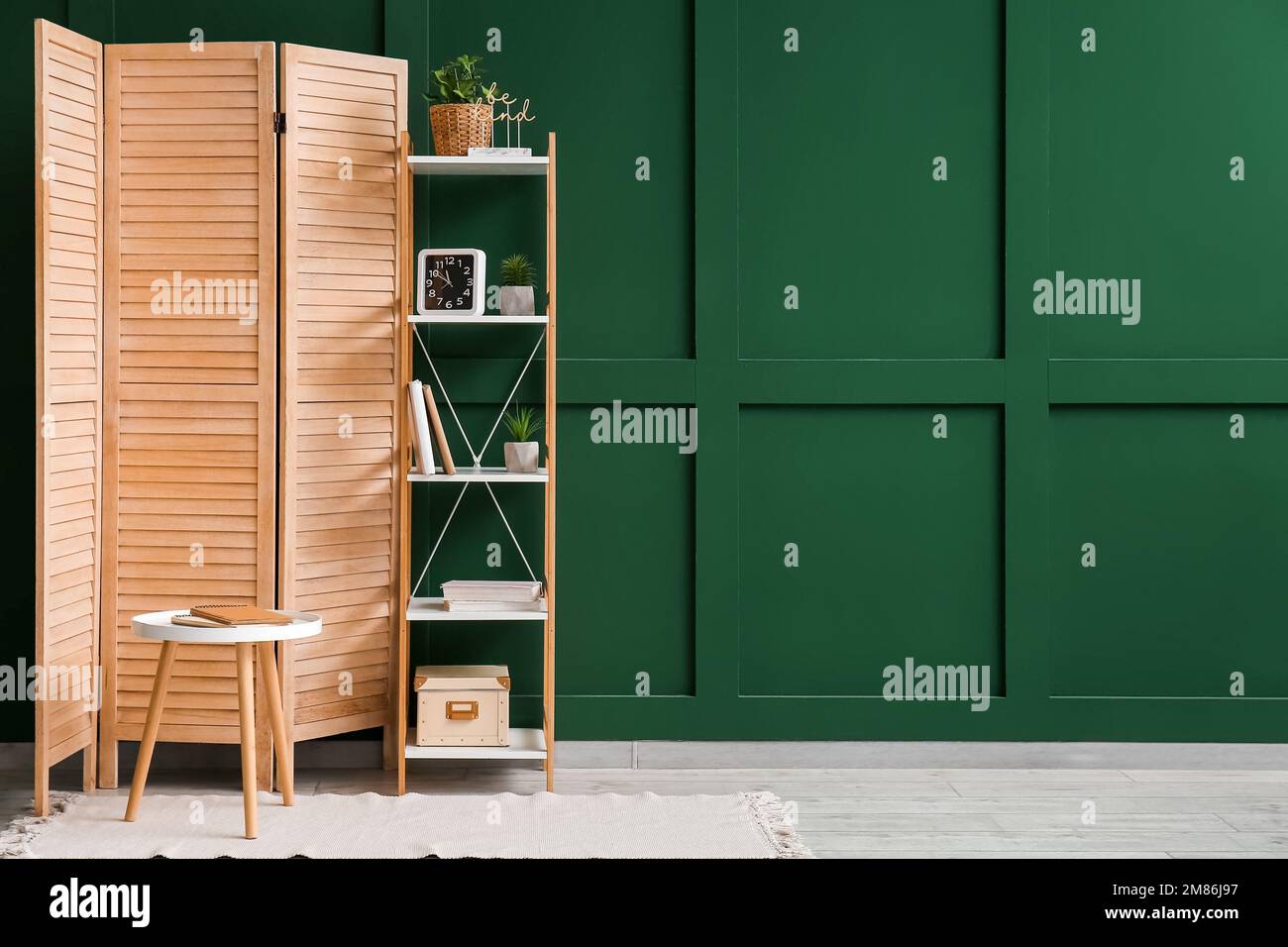 Interior of room with folding screen, shelving unit and table near ...