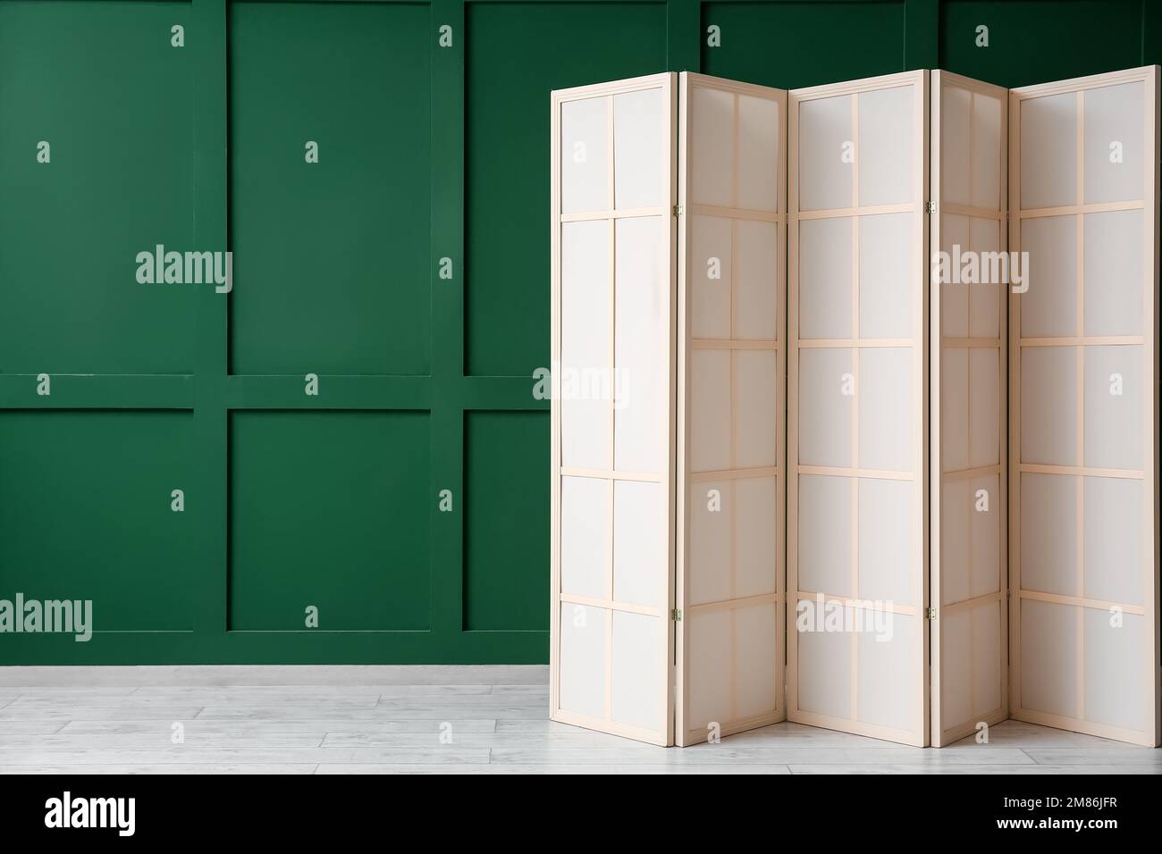 Beige folding screen near green wall Stock Photo - Alamy
