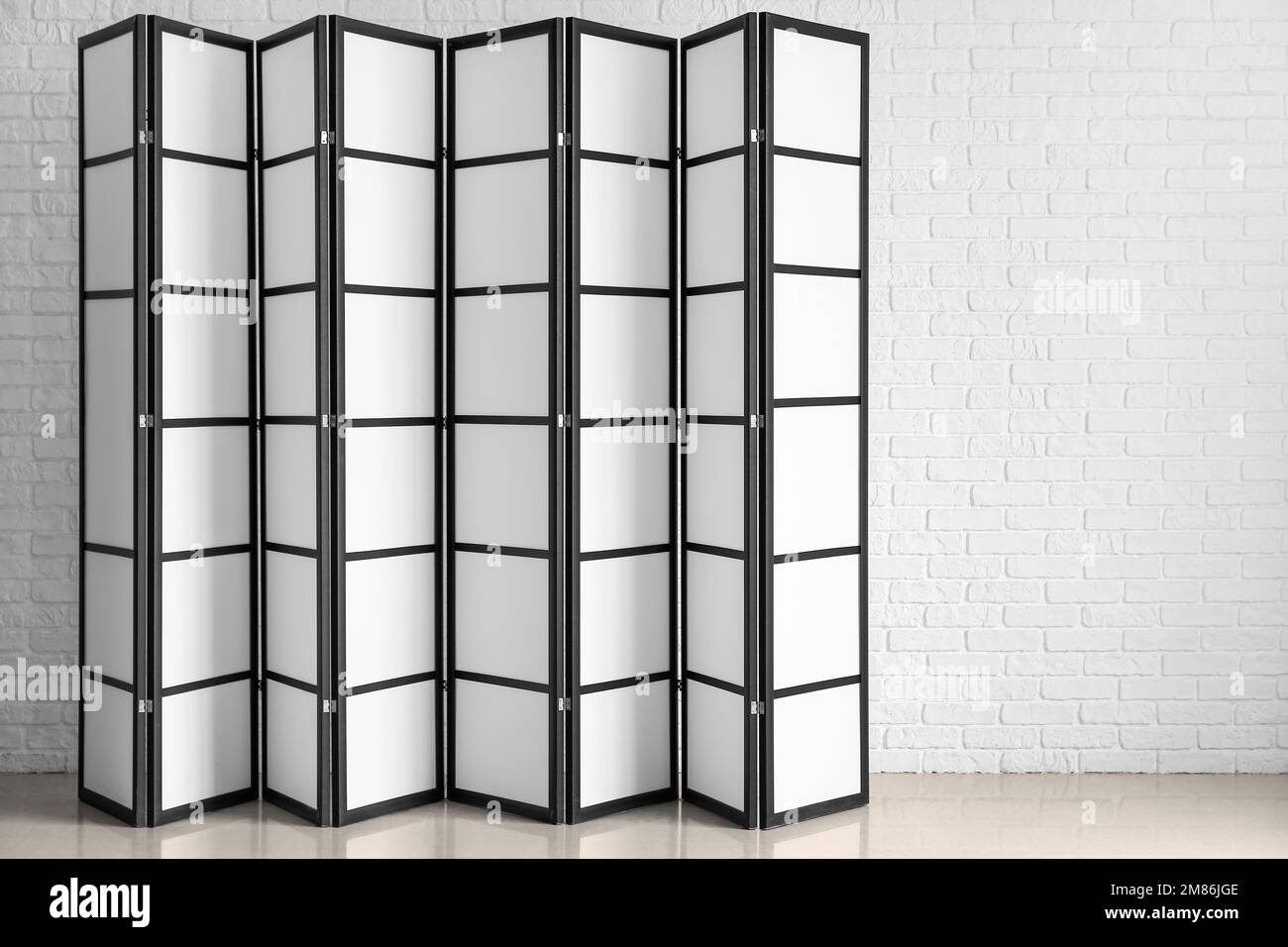 Stylish folding screen near white wall Stock Photo - Alamy