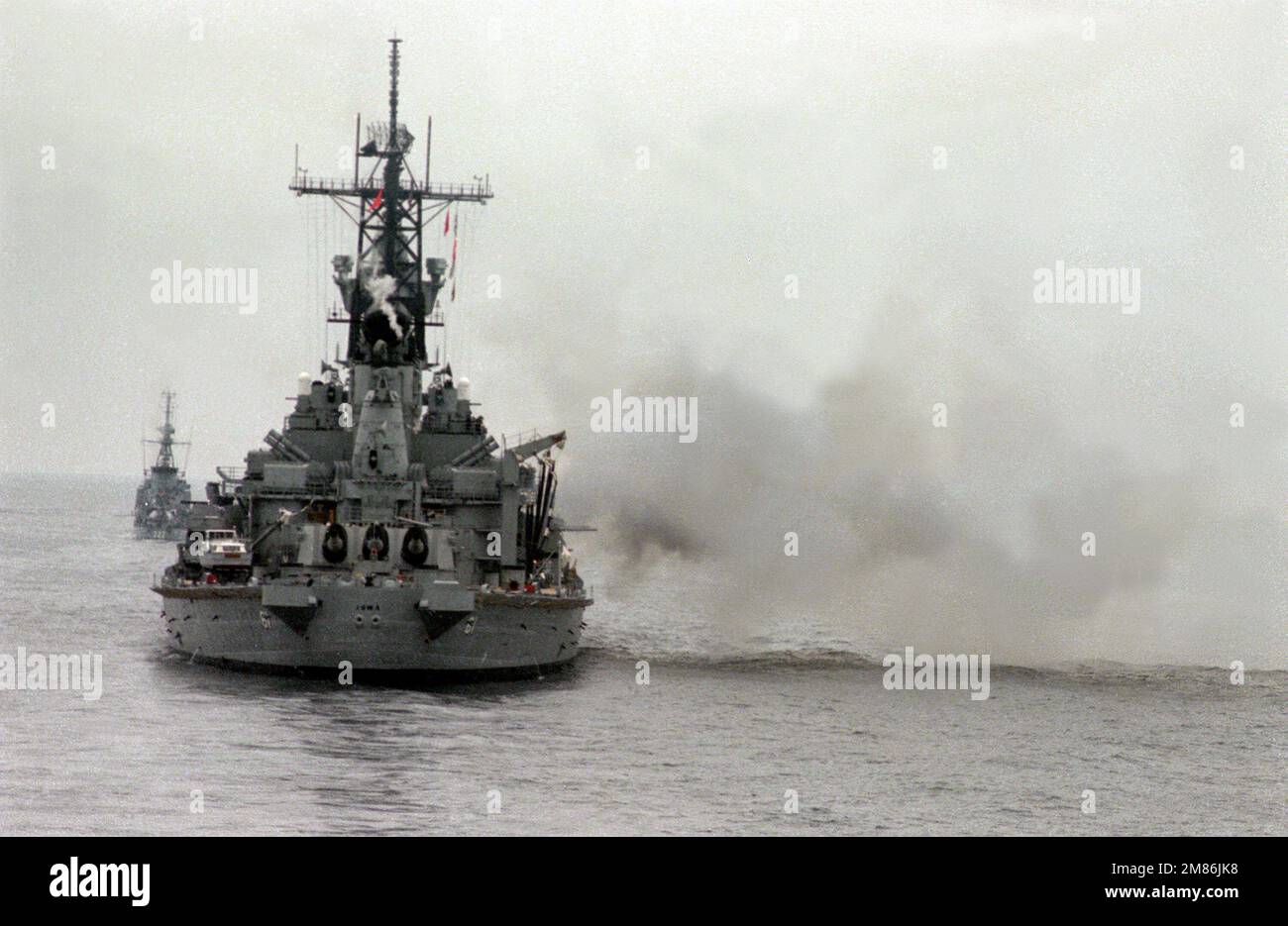 A stern view of the battleship USS IOWA (BB-61) conducting a gunnery ...