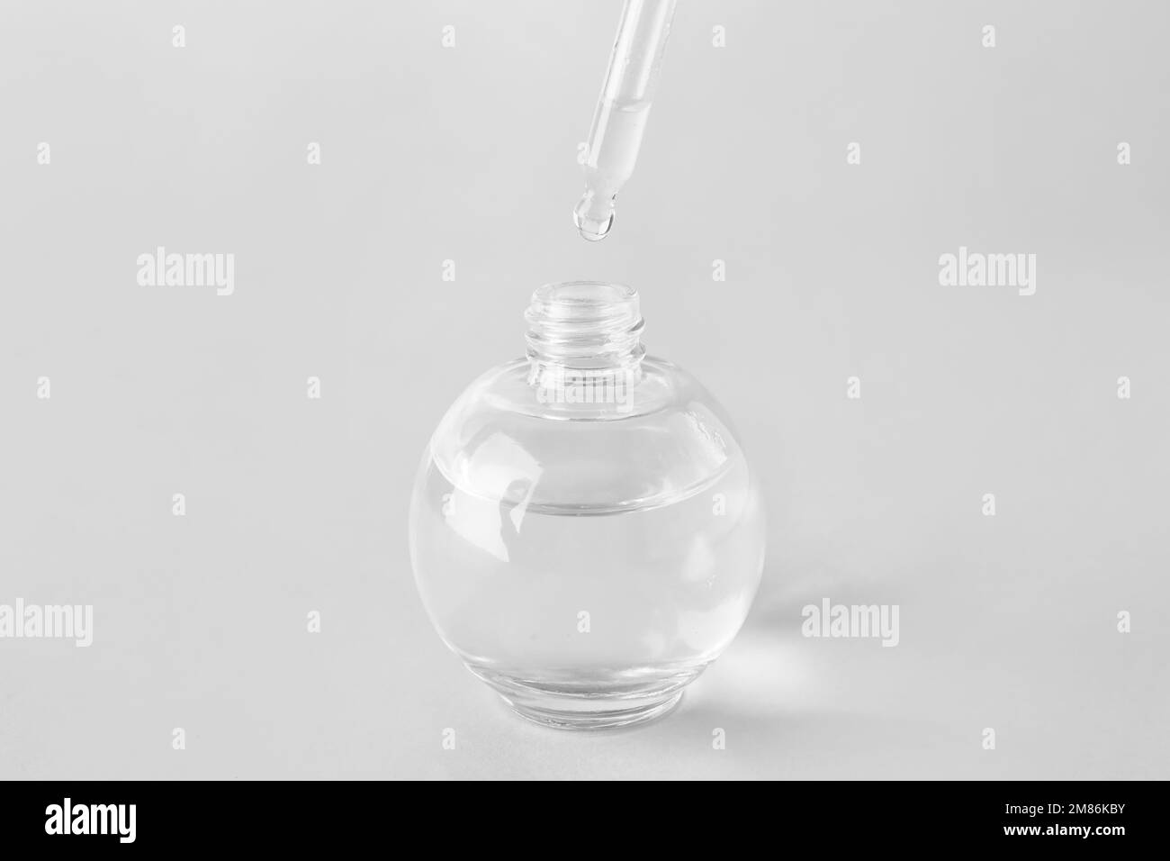 Dripping of serum from pipette into bottle on light background Stock ...