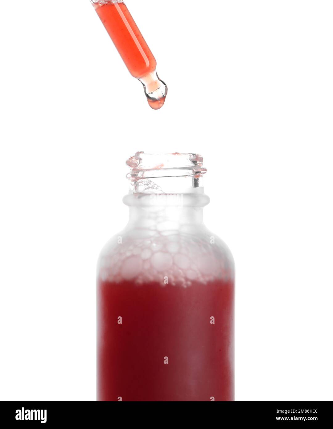 Dripping of serum from pipette into glass bottle on white background ...