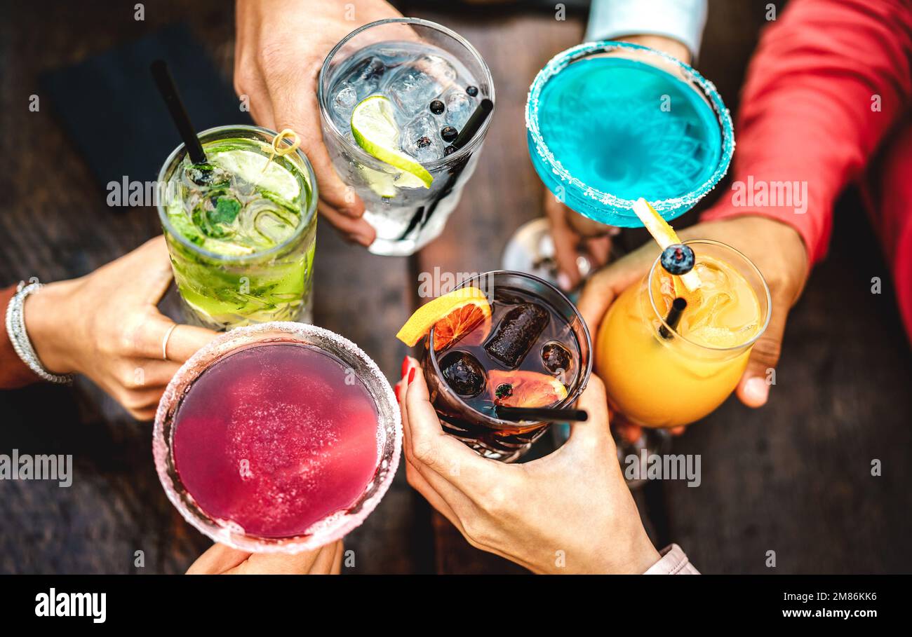 Top view of people hands toasting multicolored fancy drinks - Young ...
