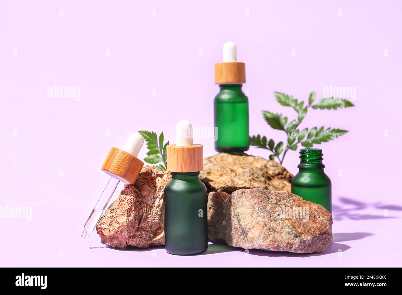 Composition with bottles of serum and stones on color background Stock ...