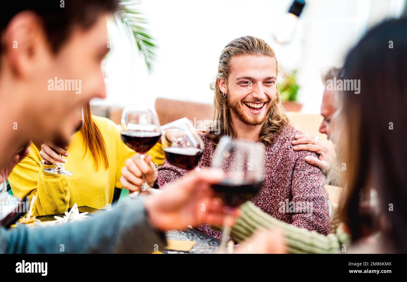 Happy people on genuine mood drinking red wine at rooftop party ...