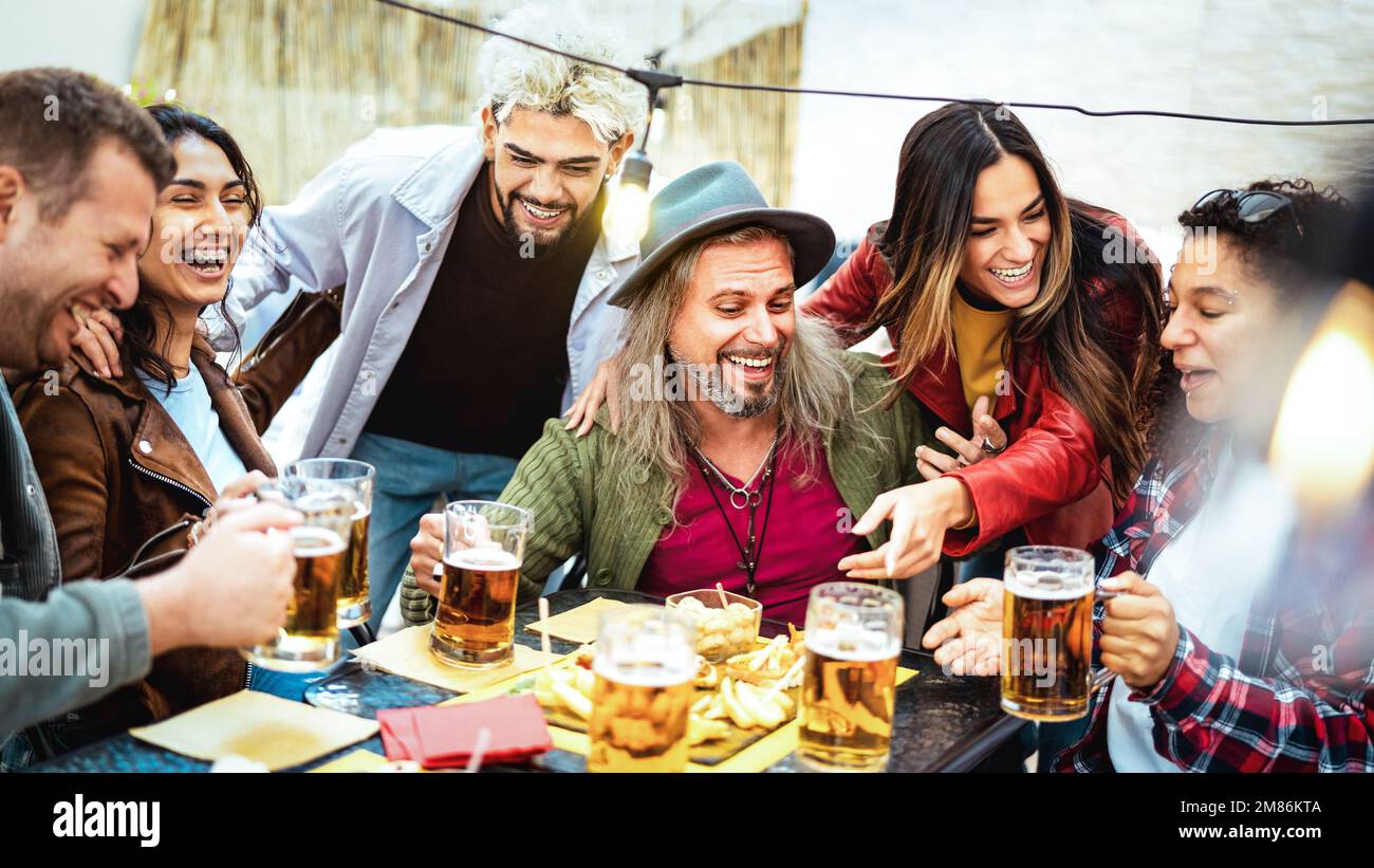 Happy mixed age people drinking and toasting beer at brewery bar ...