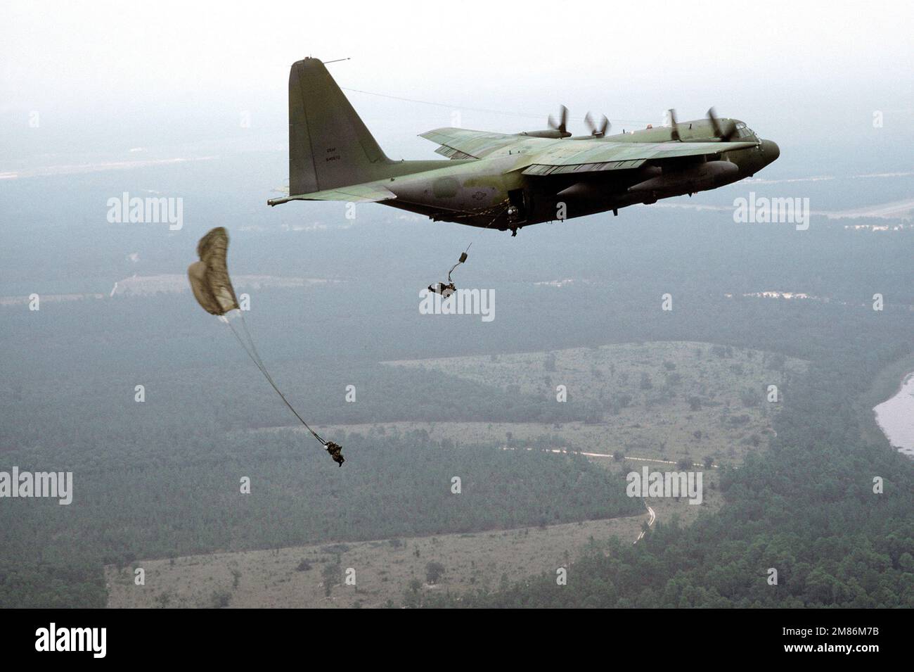 Air to air side view of paratroopers jumping from a C-130 Hercules ...