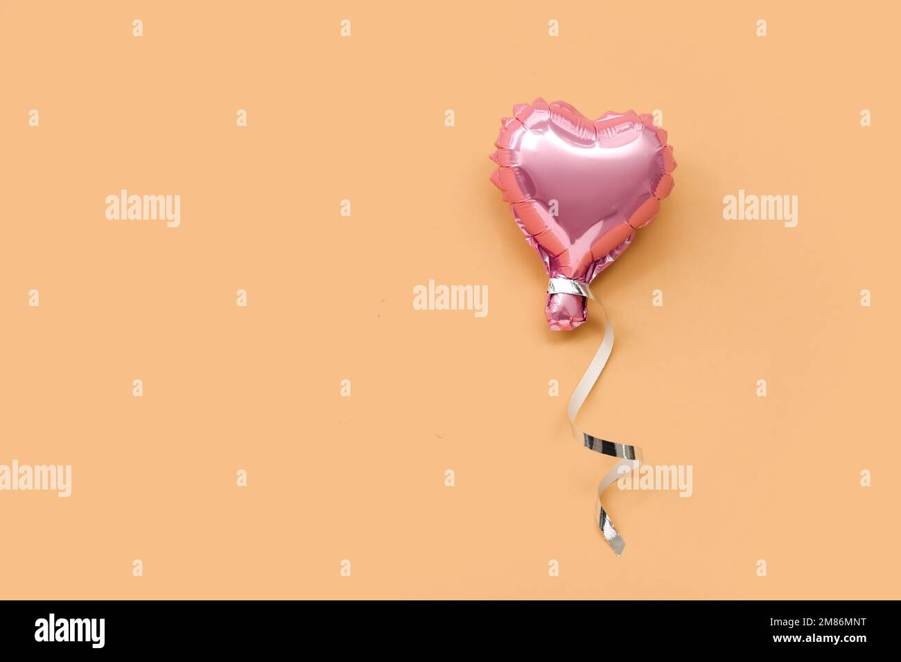 Heart shaped balloon with ribbon on color background. Valentine's Day ...