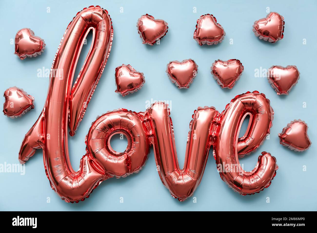 Balloon in shape of word LOVE among heart shaped ones on color ...