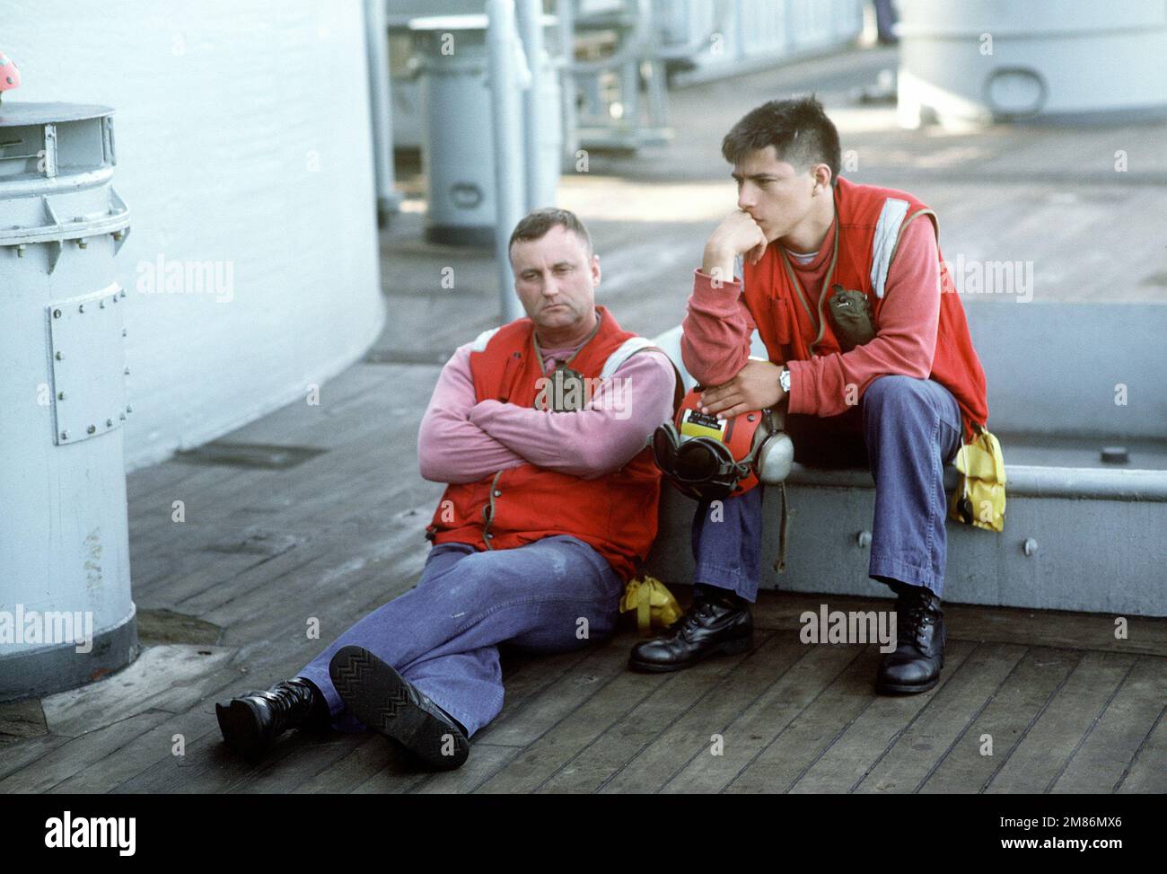 Crew members take a break from their duties aboard the battleship USS ...