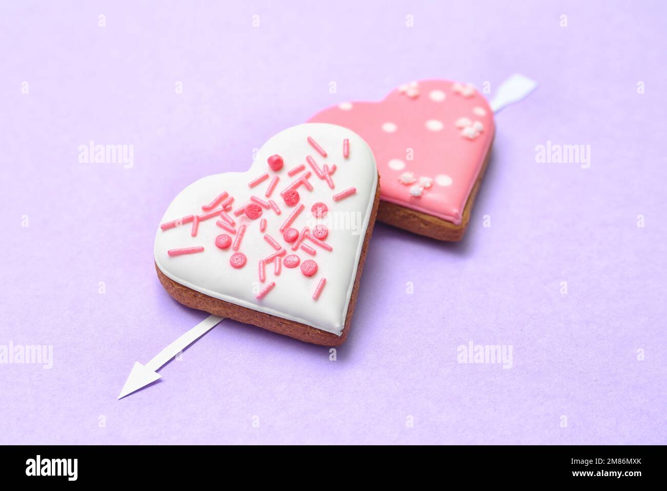 Composition with tasty heart shaped cookies and paper arrow on color ...