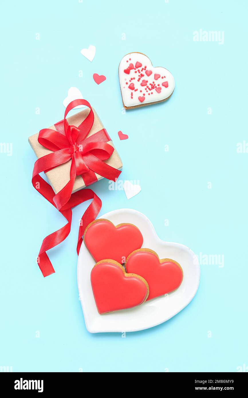 Composition with tasty heart shaped cookies and gift box on color ...