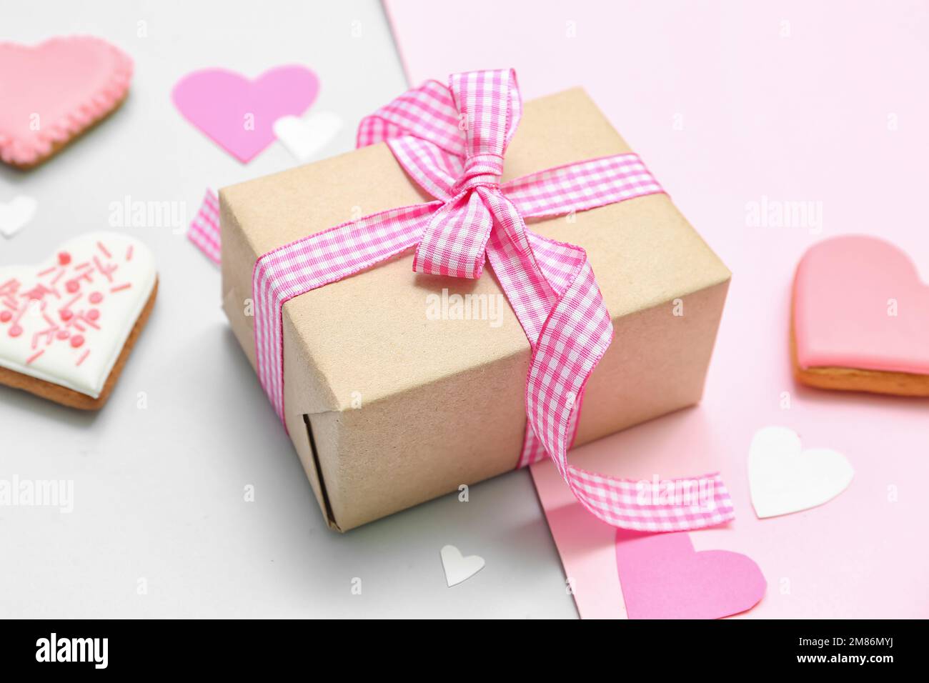 Gift box and tasty heart shaped cookies on color background. Valentine ...