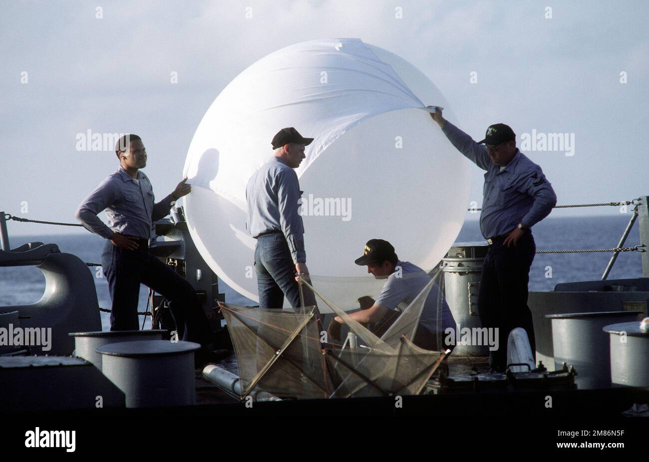 Crew members prepare to release a weather/wind velocity balloon prior ...