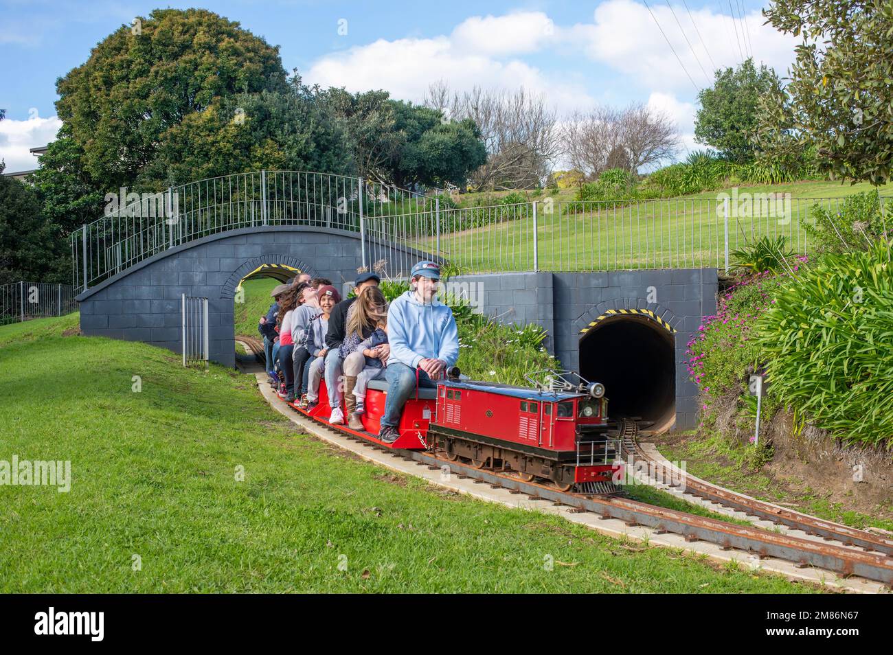 A lovely family on a miniature train on an evergreen hill in Auckland ...