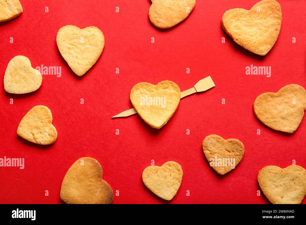 Composition with tasty heart shaped cookies and wooden arrow on red ...