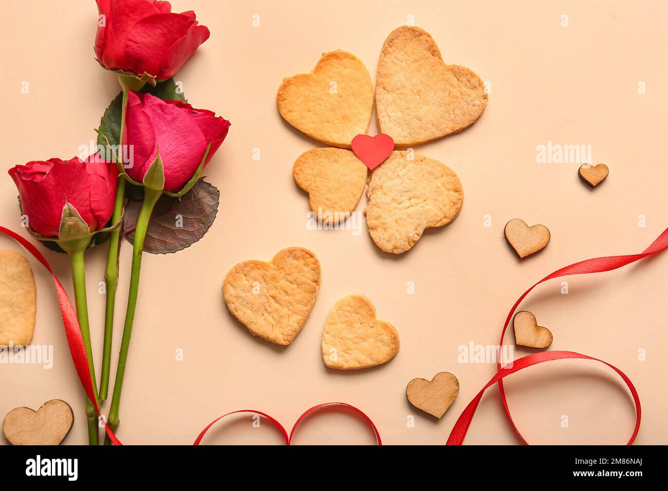 Composition with sweet heart shaped cookies, ribbon and rose flowers on ...