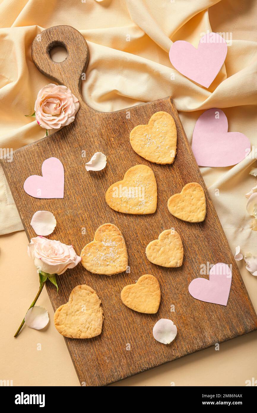 Composition with wooden board of sweet heart shaped cookies and rose ...