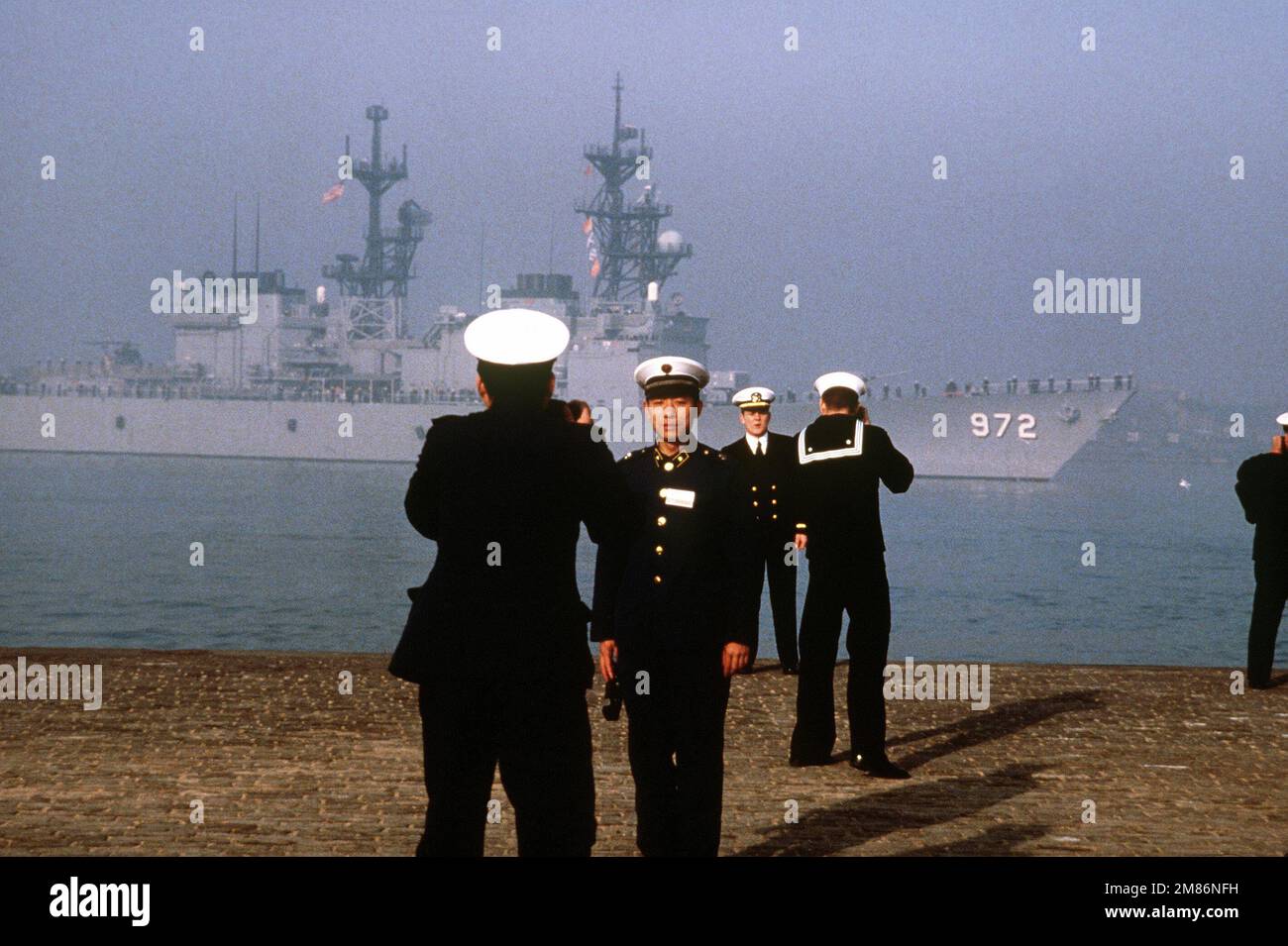 Chinese and American sailors pose for photographs at pier side as the ...