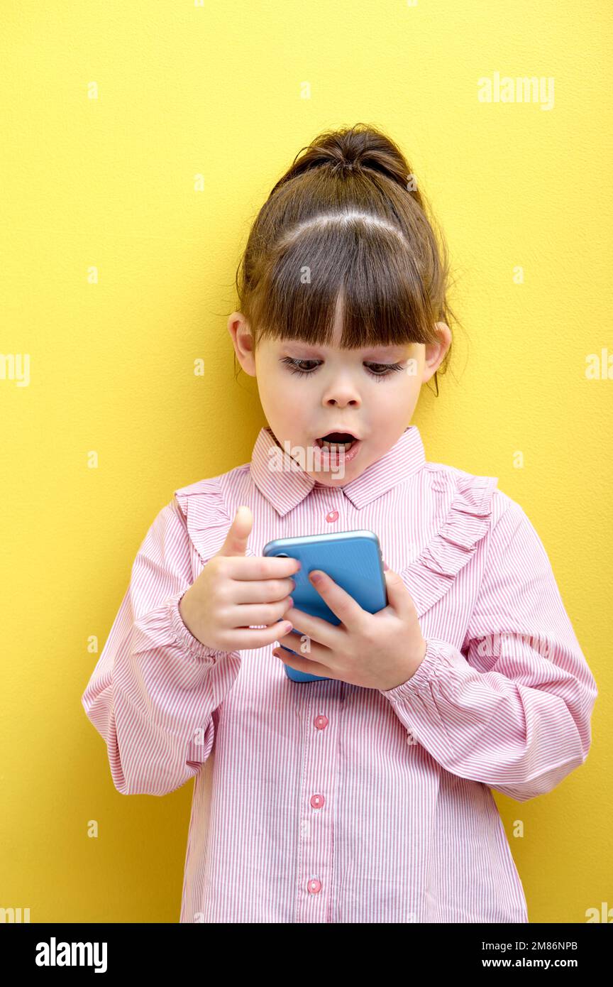 wow, how interesting. kid girl looking at screen of mobile phone ...