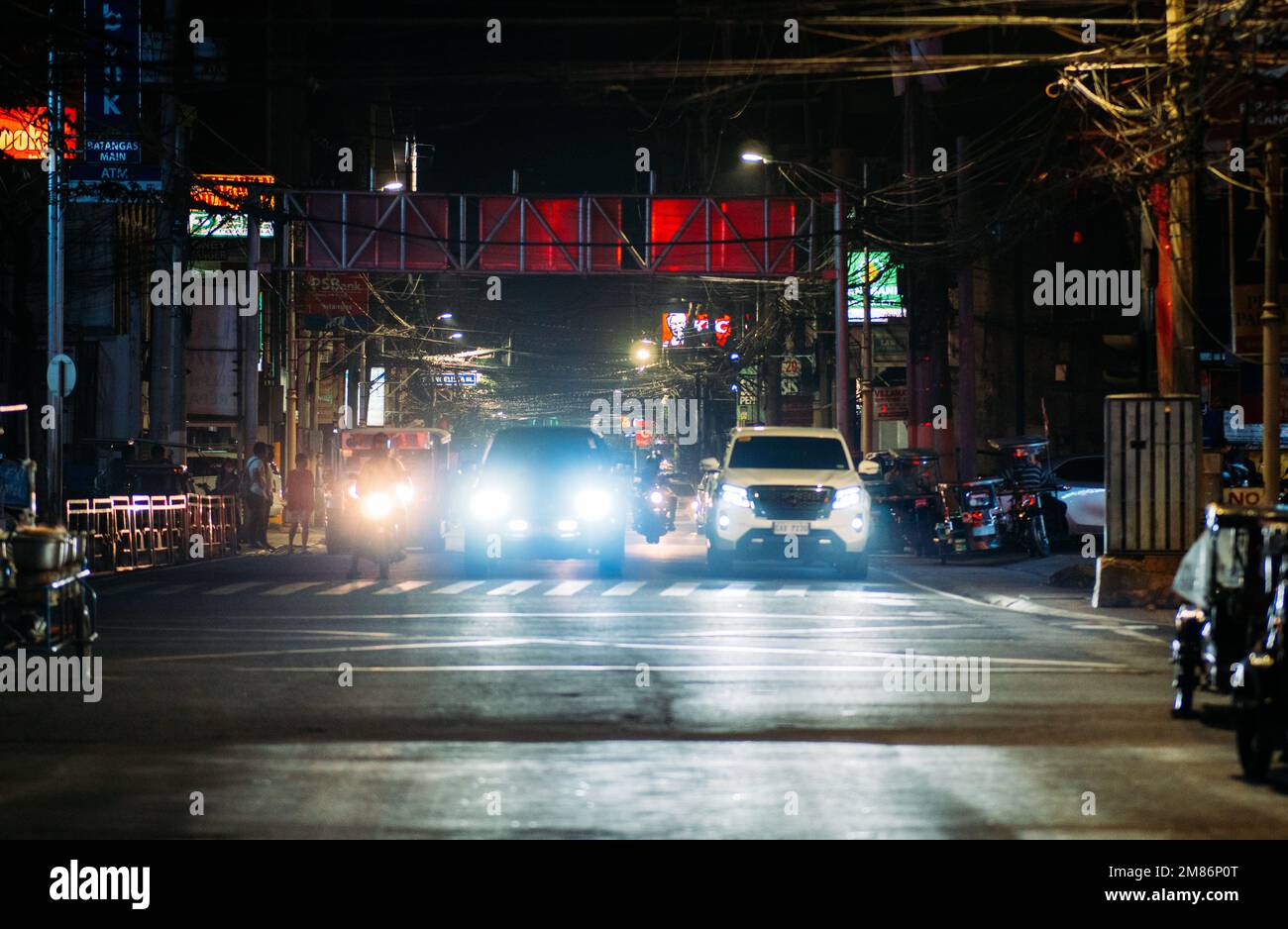 A dark night in the Philippines with cars lighting up the road ahead ...