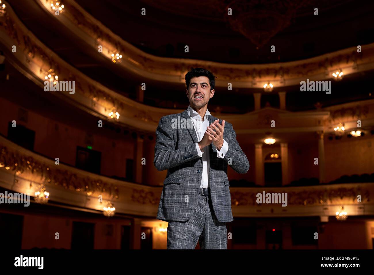 Talented business couch standing on stage clapping hands, keep hands ...