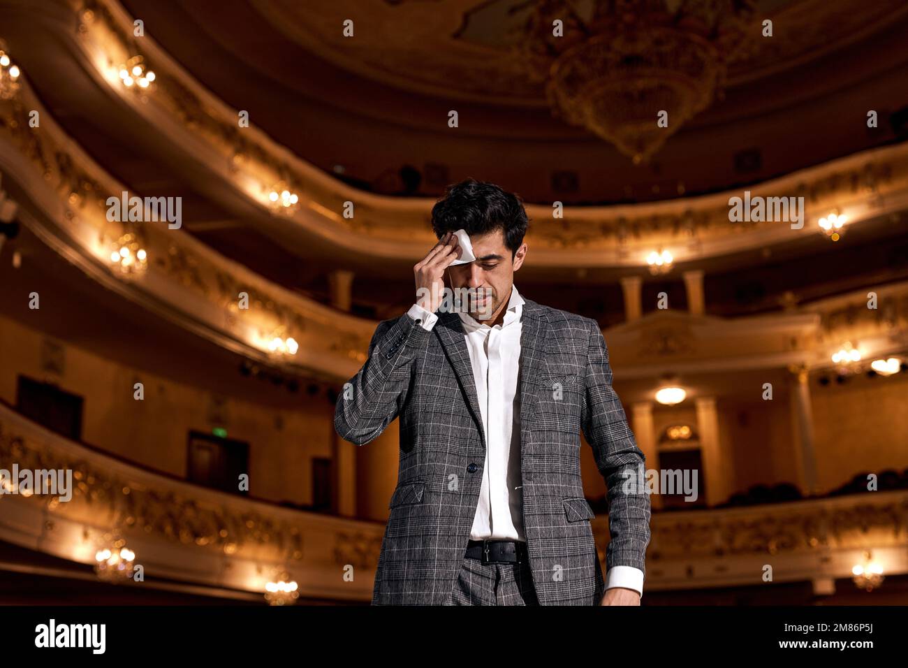 scared european speaker in suit standing at podium stage holding napkin ...