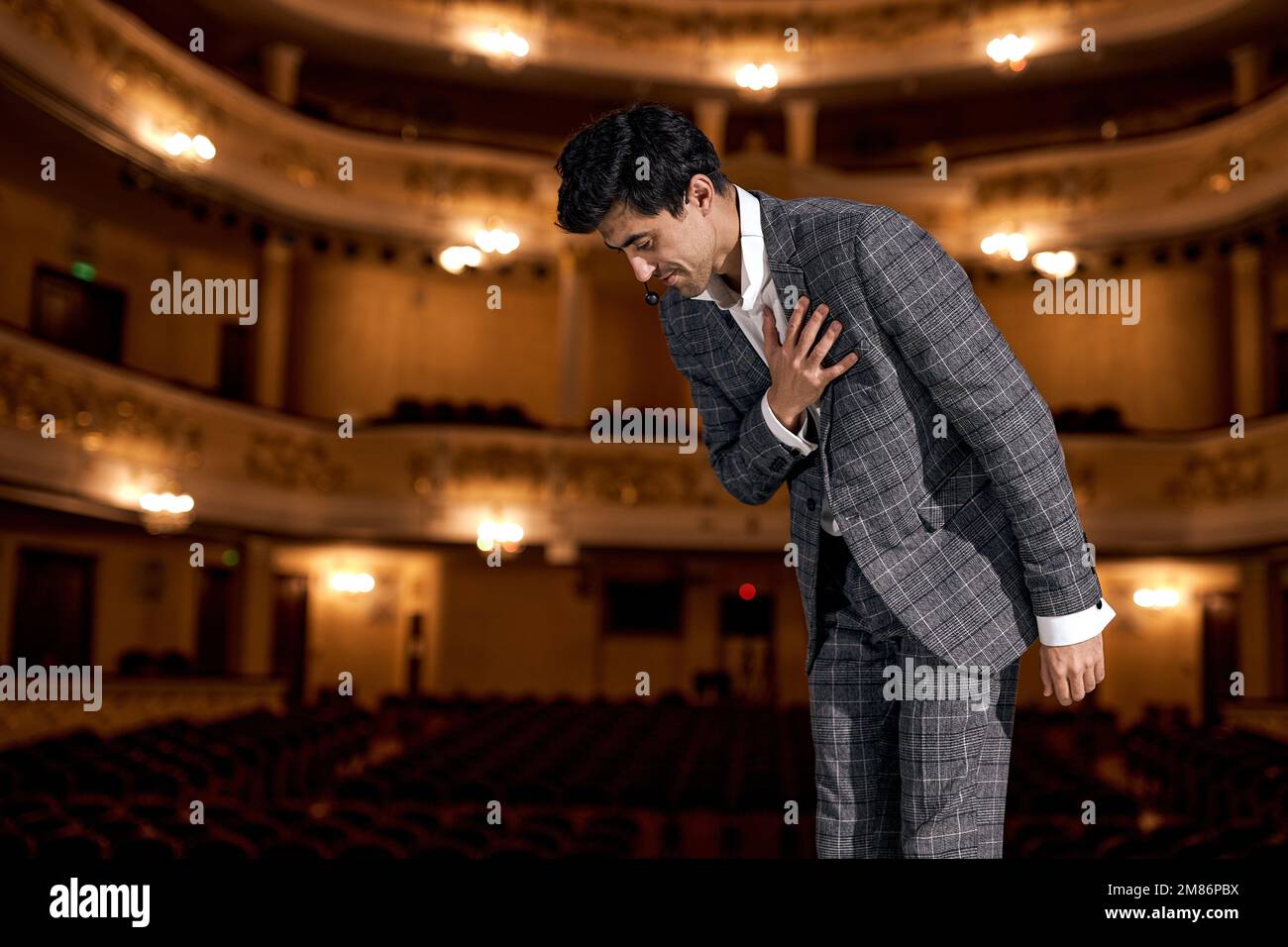 man Presenter in elegant classic suit on Stage is expressing gratitude ...