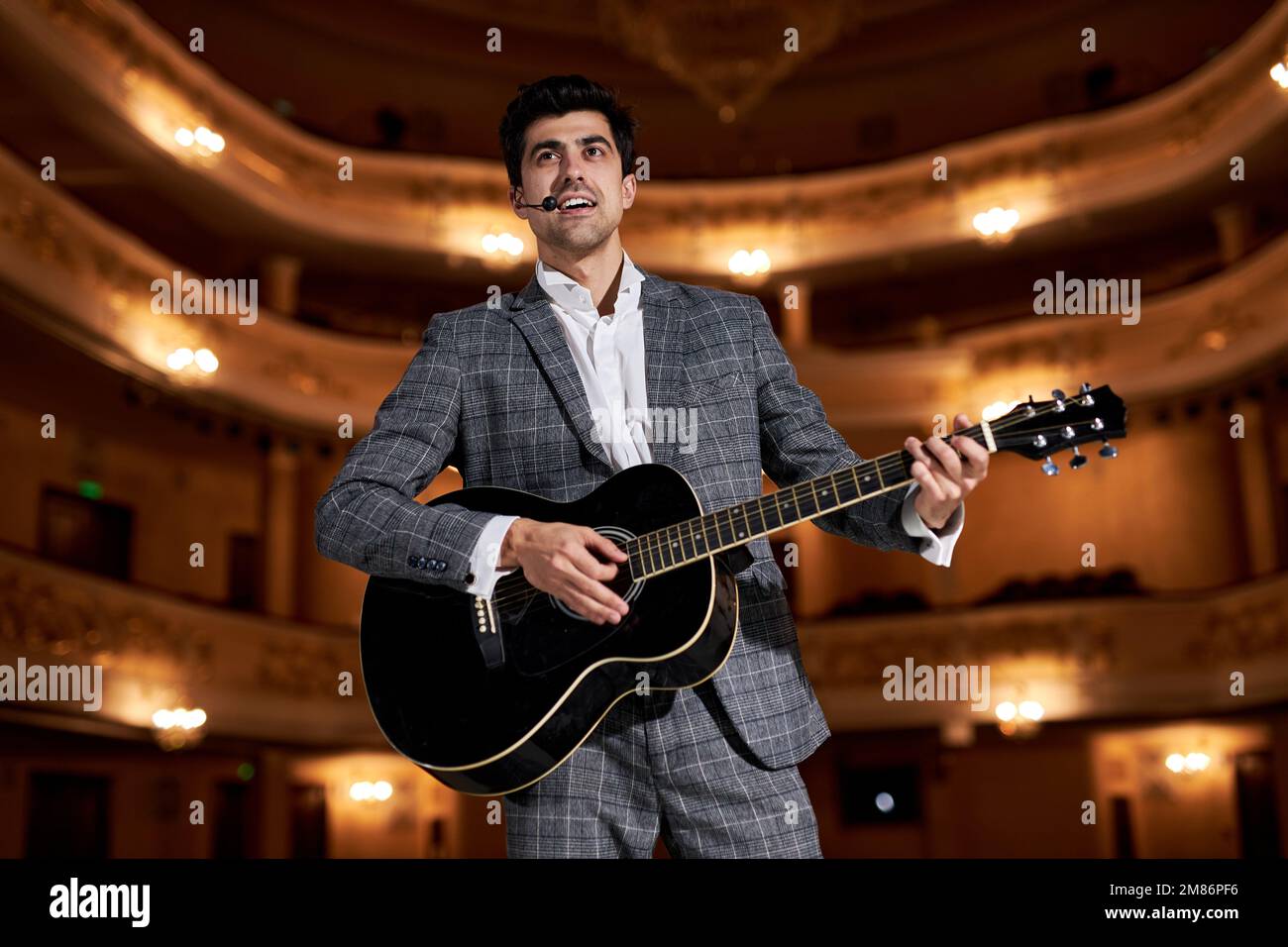 singer Guitar player in elegant classic suit performing playing guitar ...