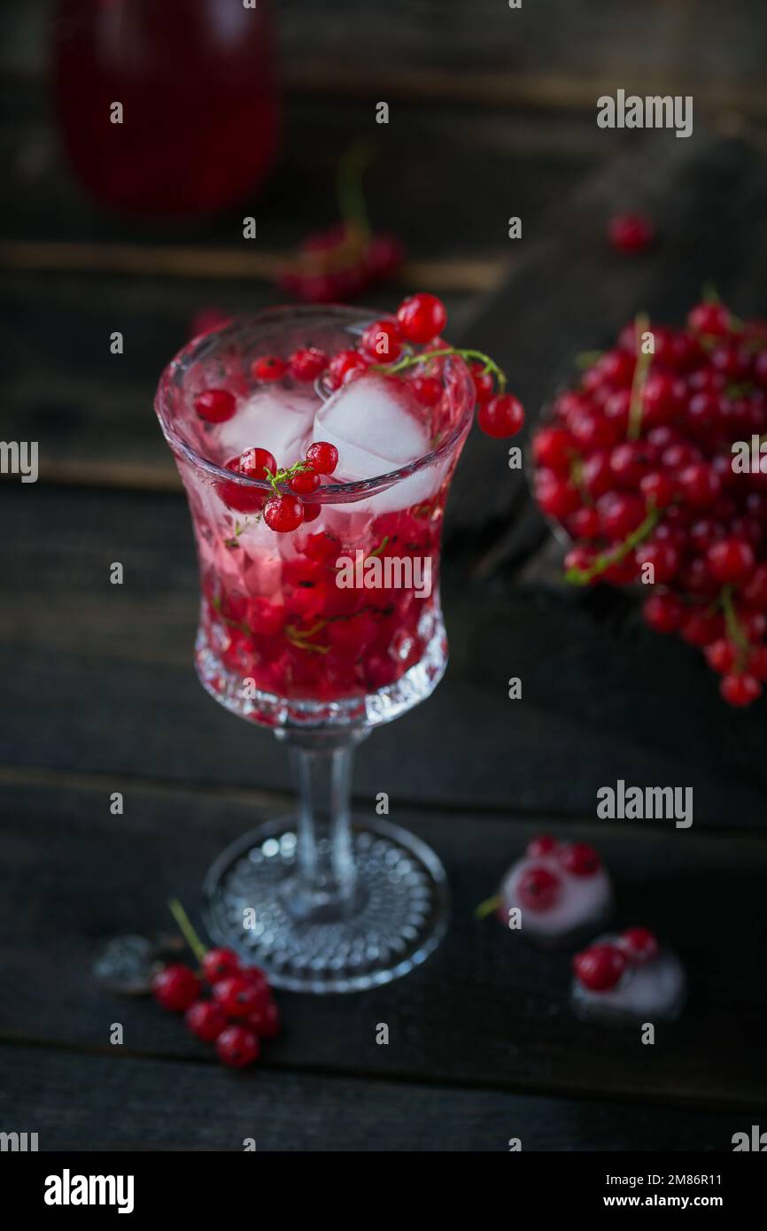 Glass of red currant cocktail or mocktail, refreshing summer drink with ...