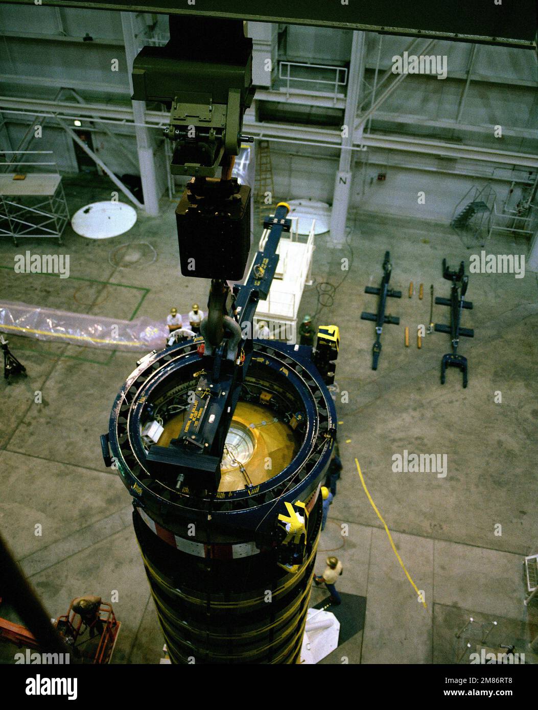 A crane is used to raise the first stage of an LGM-118A Peacekeeper ...