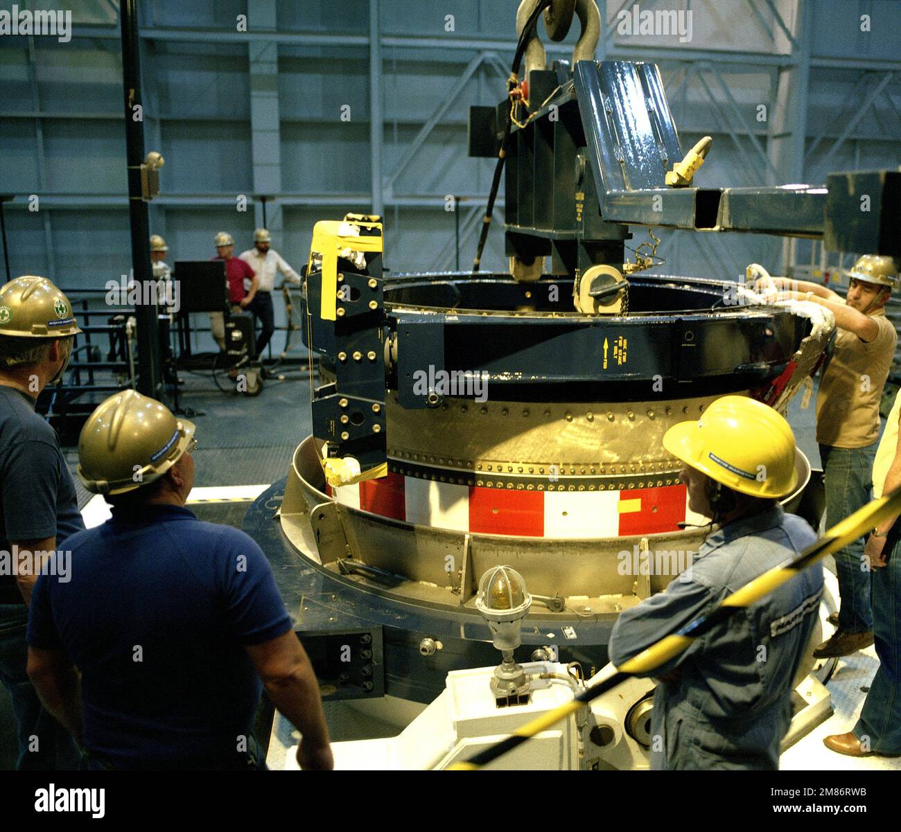 Technicians from Martin Marietta stand by as a crane is used to lower ...