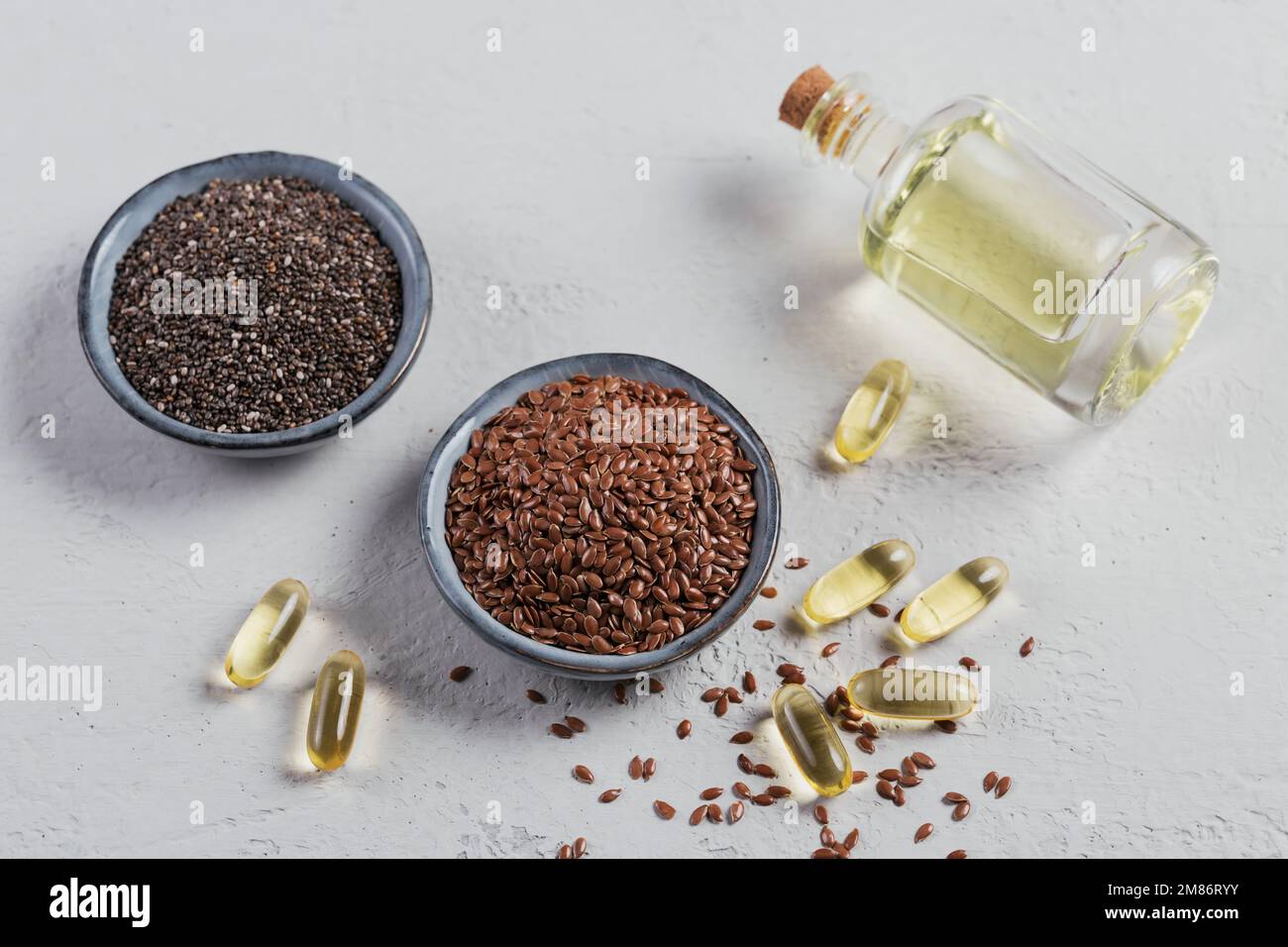 Brown flax seed or linseed and chia in small bowl and gelatin capsules ...