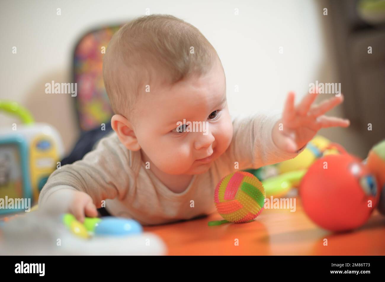 Baby plays with toys. Close-up view of cute baby boy lies on its ...