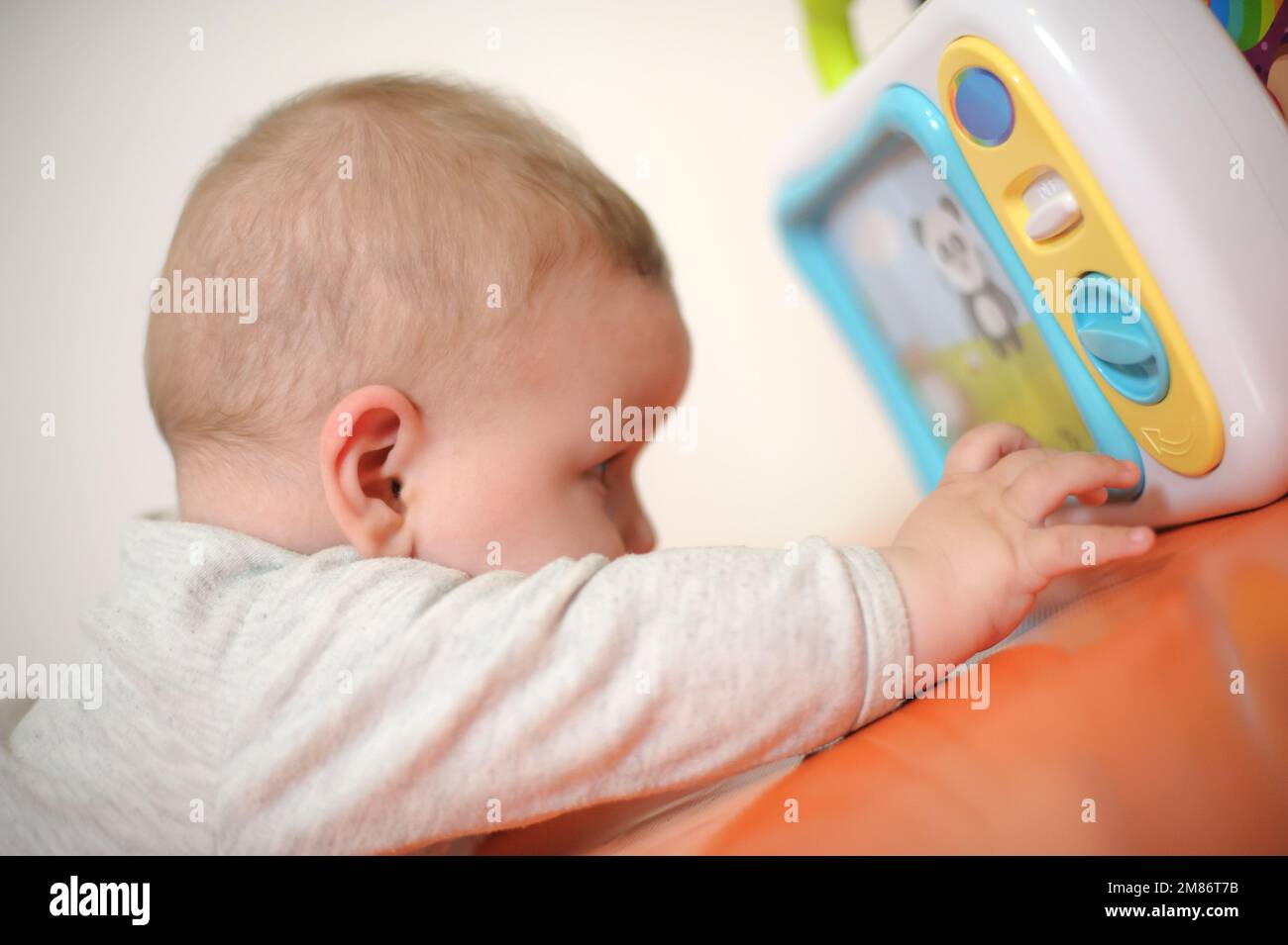 Baby plays with toys. Close-up view of cute baby boy lies on its ...