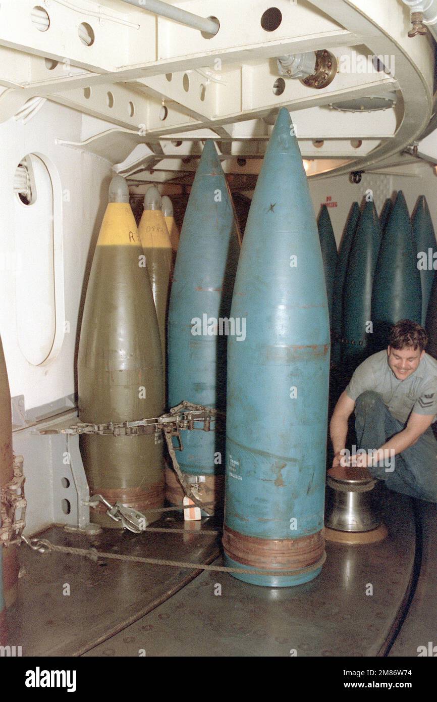 A petty officer tends a line as a 2,700-pound dummy projectile is drawn ...
