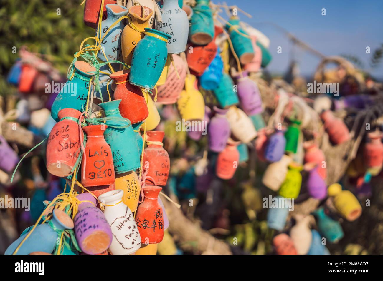 Wish tree. Small multi-colored jugs with inscriptions, wishes hanging ...