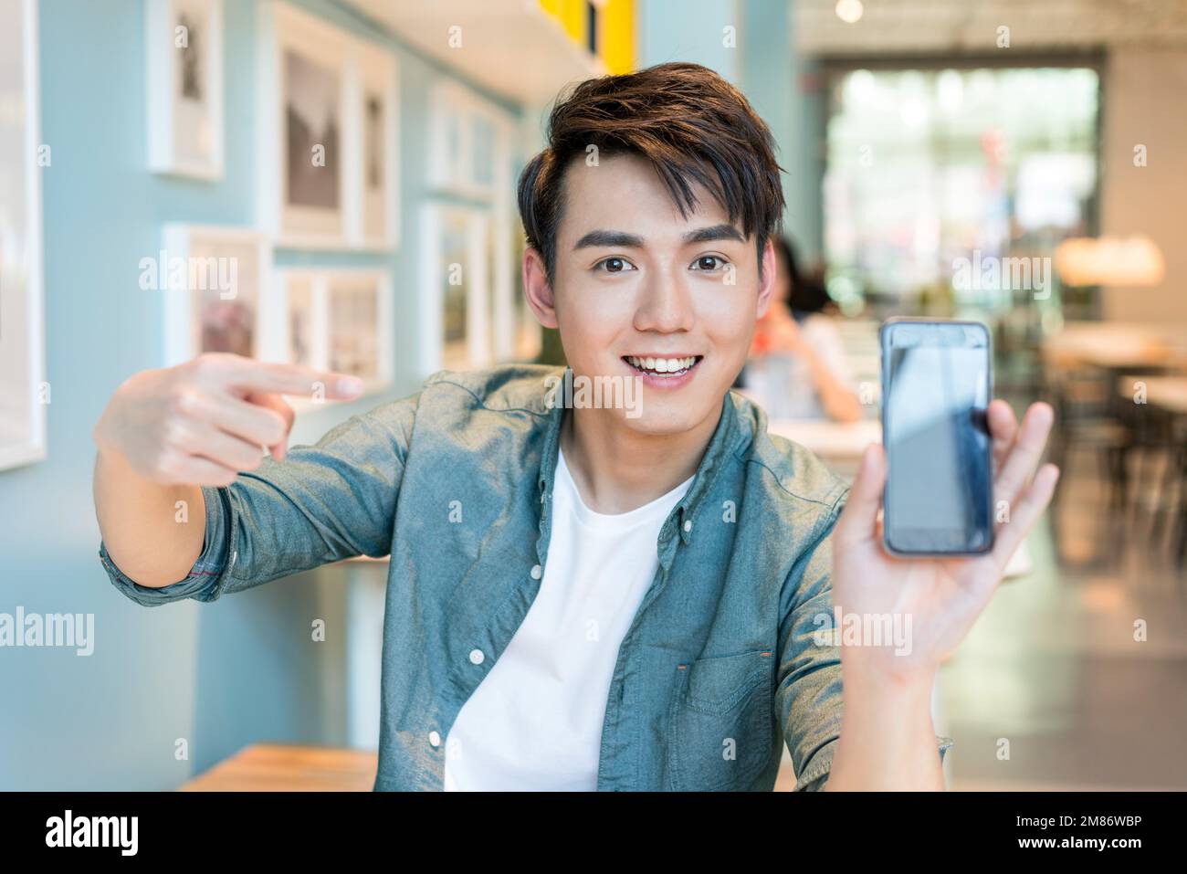 Young men show a mobile phone Stock Photo - Alamy