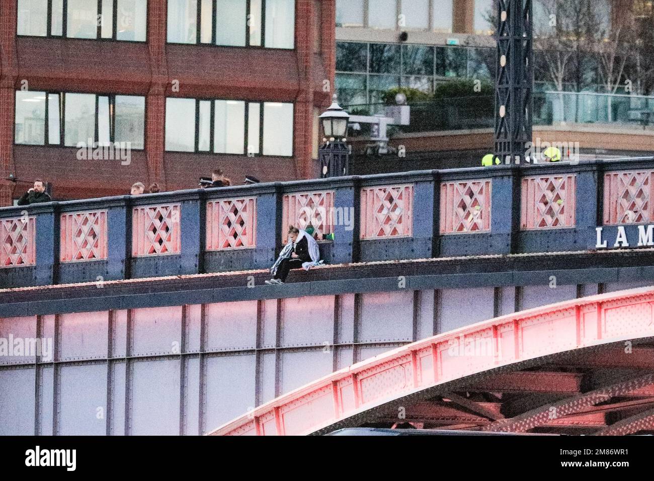 London, UK. 12th Jan, 2023. The woman can be seen on the outer ledge of ...