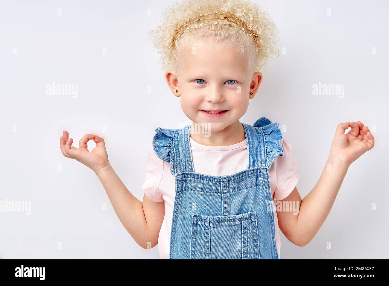calm child girl meditating isolated on white studio background. cute ...
