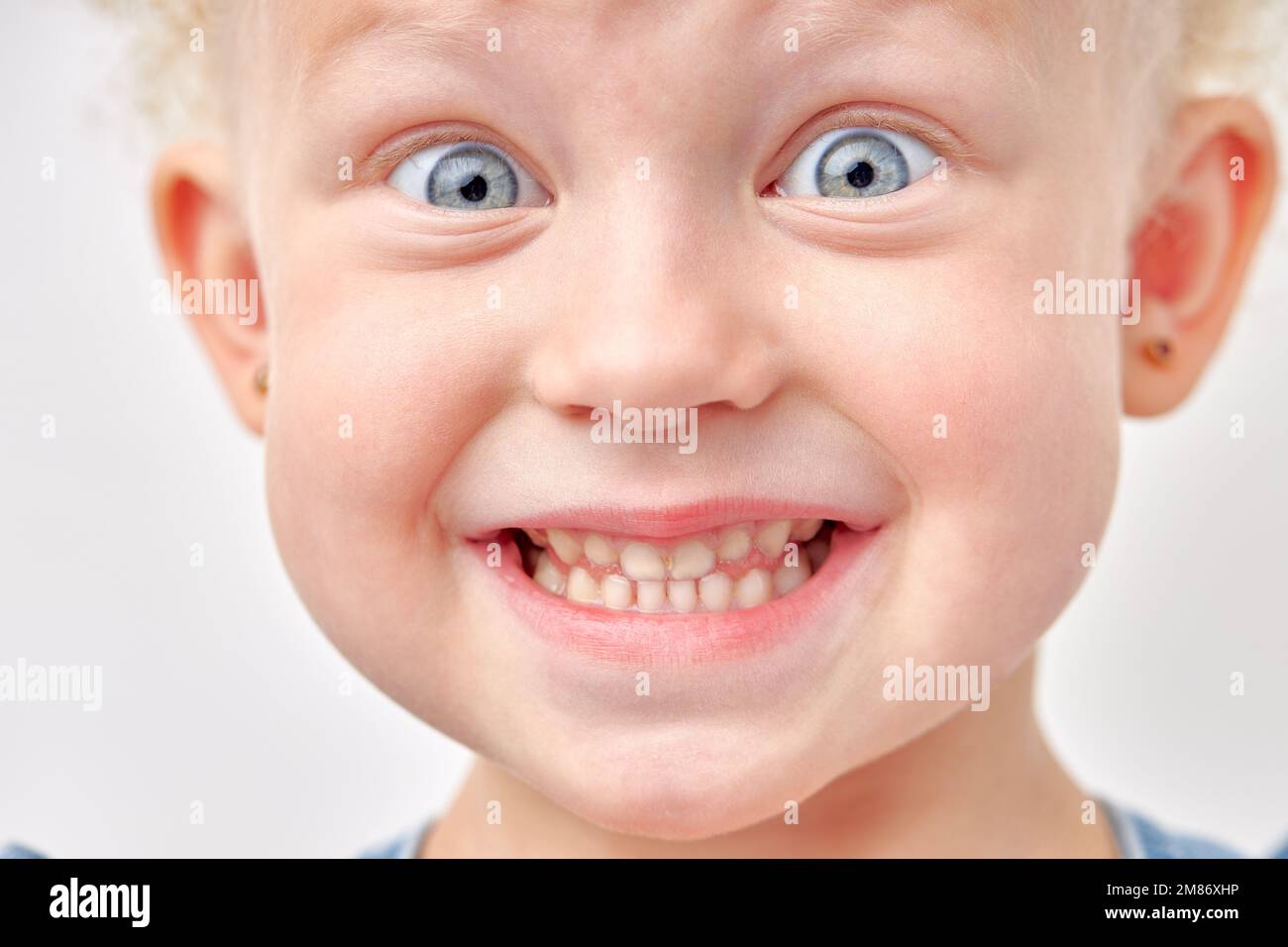 Happy caucasian kid girl has broad smile, shows perfect teeth over ...
