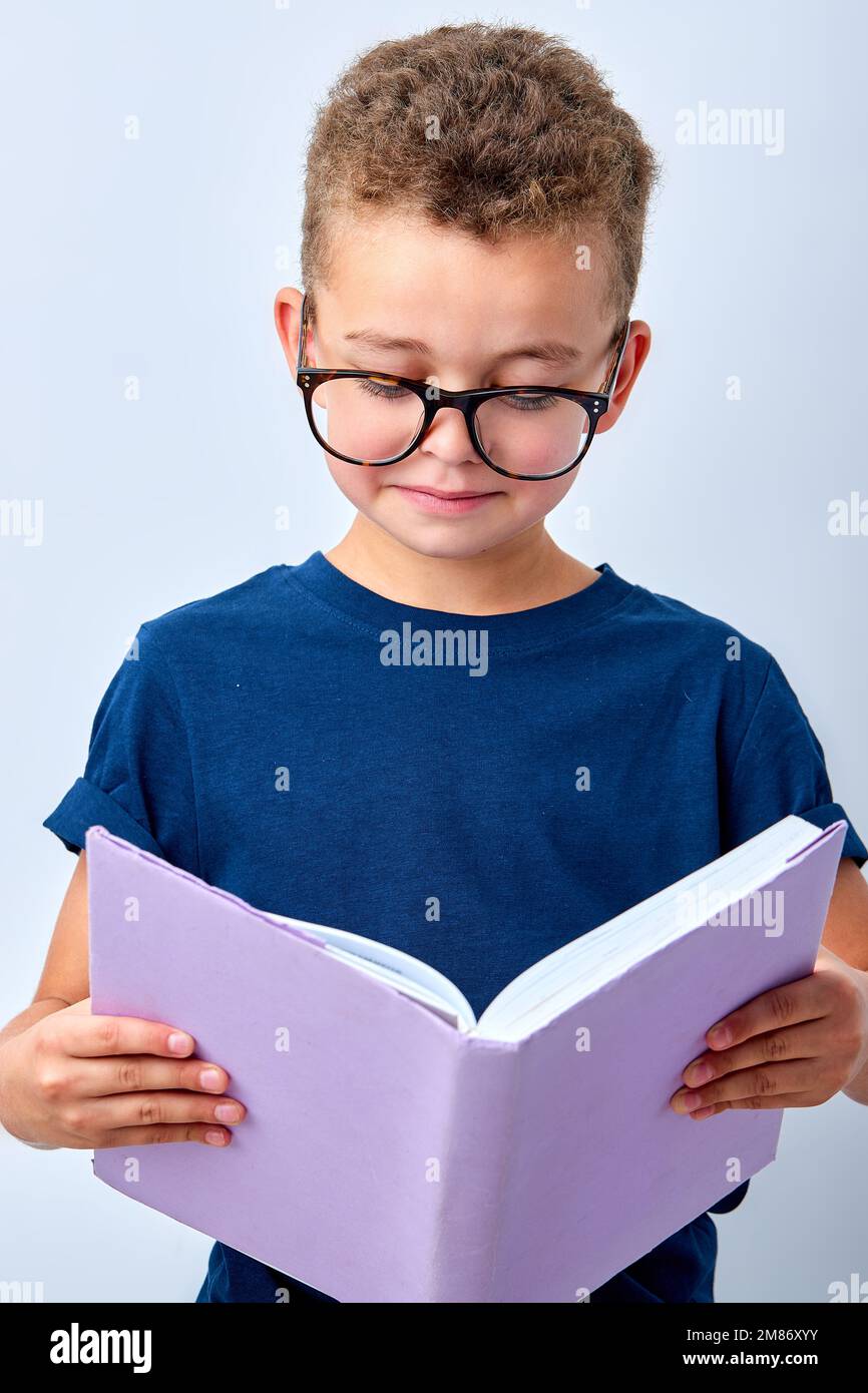 diligent kid boy reading fascinating book during school studies against ...