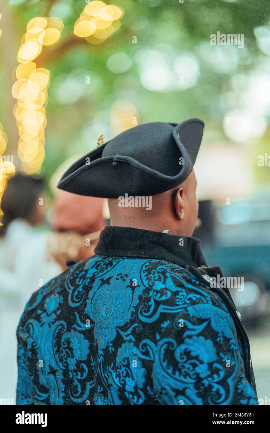 A vertical shot of the man from behind wearing black and blue coat and ...