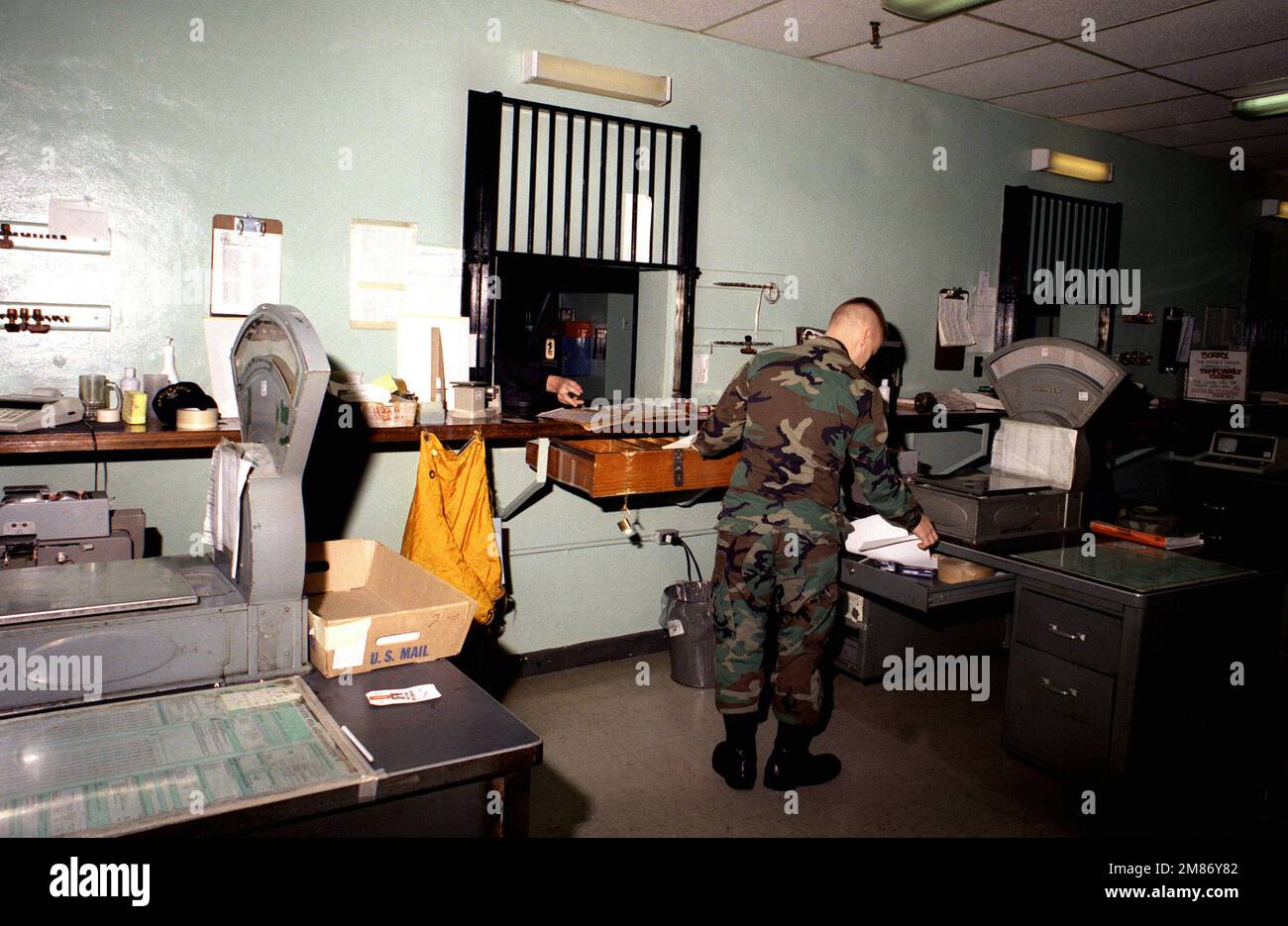 Lance Corporal Wille, a Marine postal clerk, waits on a customer in the ...