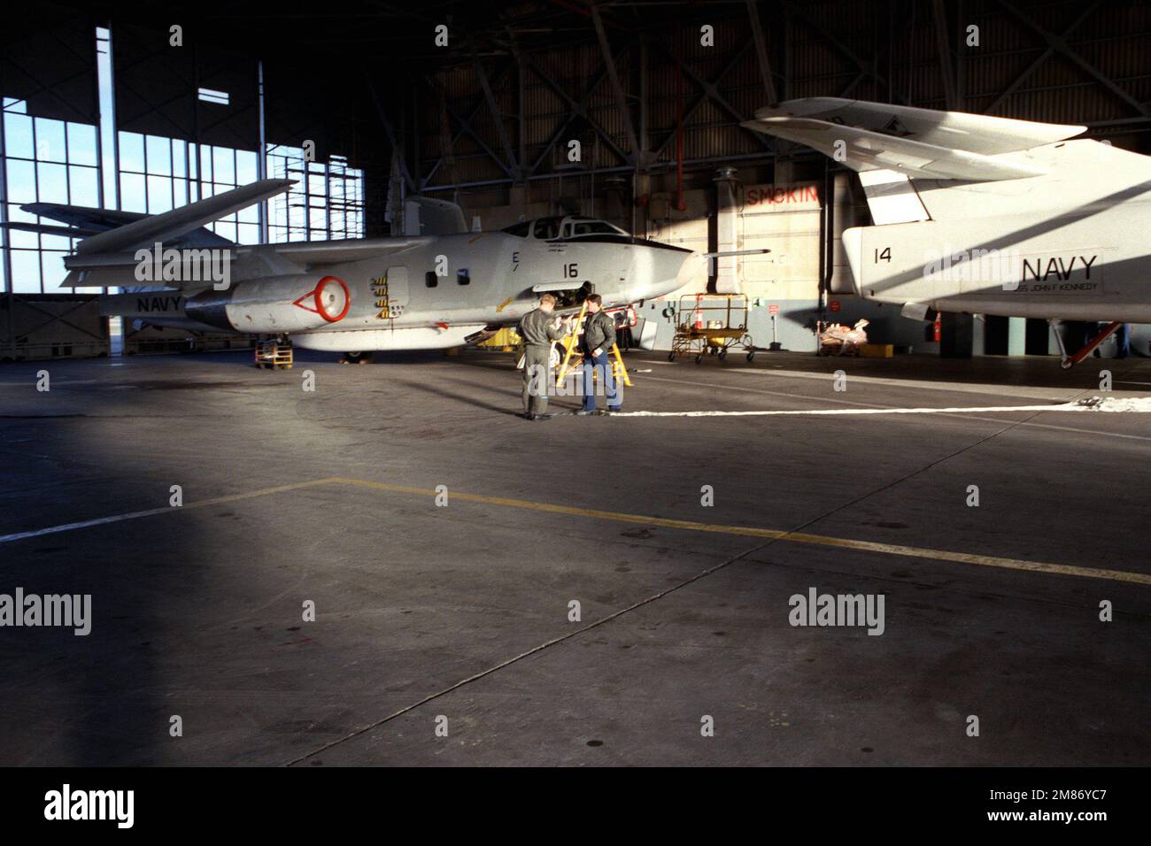 Two saliors confer near an EA-3B Skywarrior aircraft assigned to Fleet ...