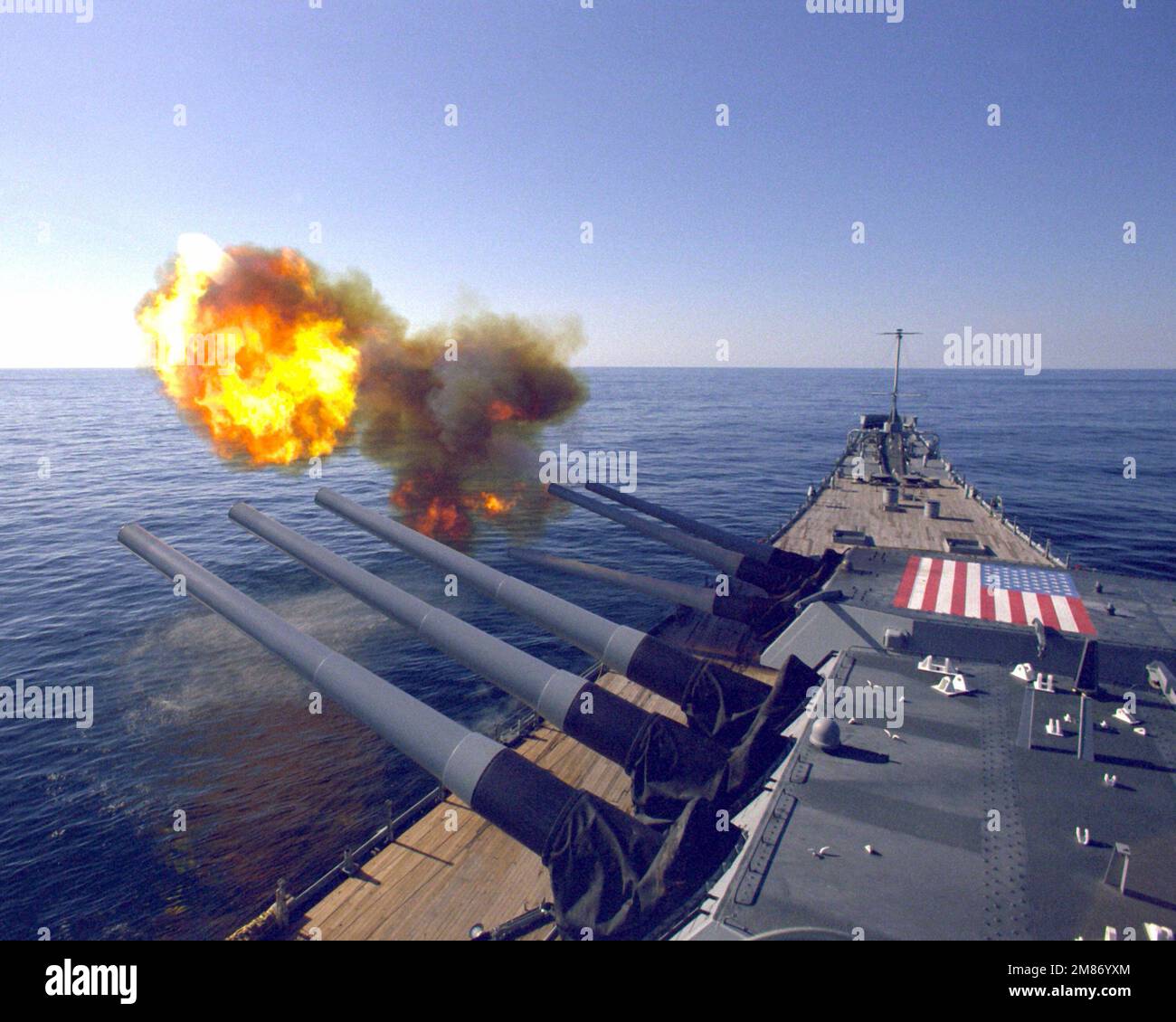A projectile is fired from the center Mark 7 16-inch/50-caliber gun in the No. 1 turret aboard ...
