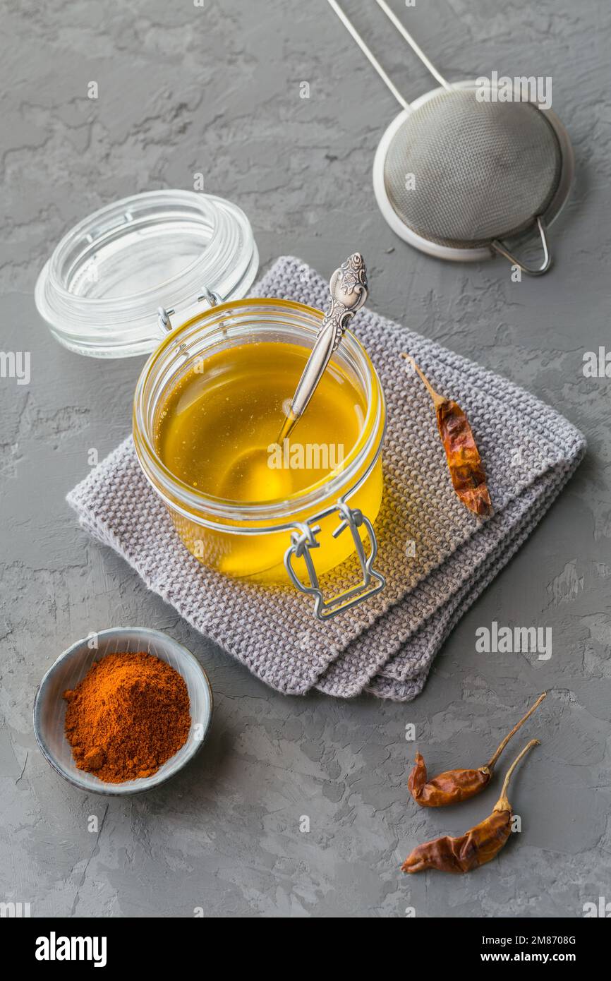 Healthy homemade Ghee or clarified butter in a jar, chili and paprika ...